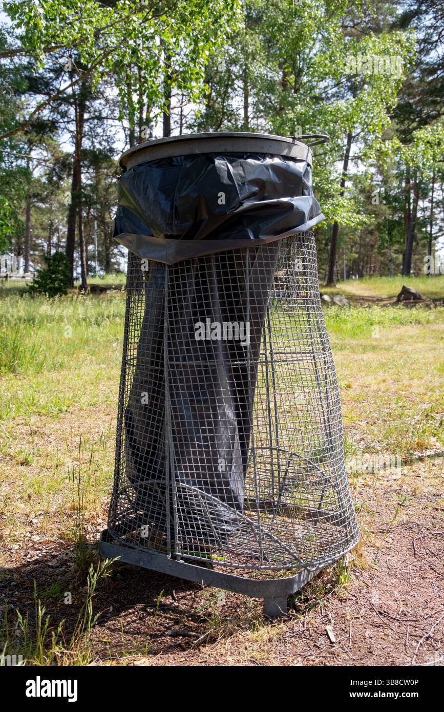 A trash can sits in a metal cage in a wideopen field Stock Photo - Alamy