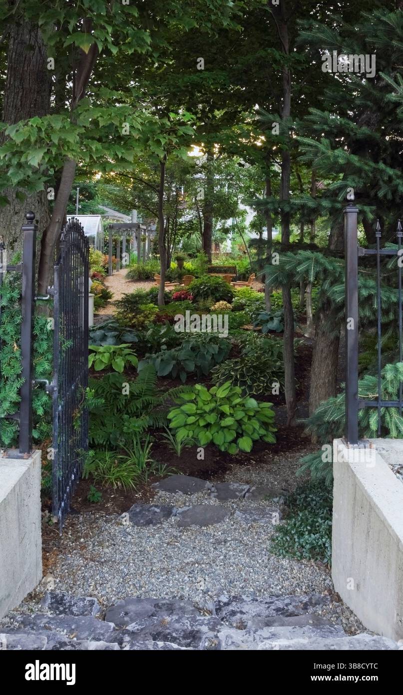 Stone steps and opened wrought iron fence gate leading to collection of ...