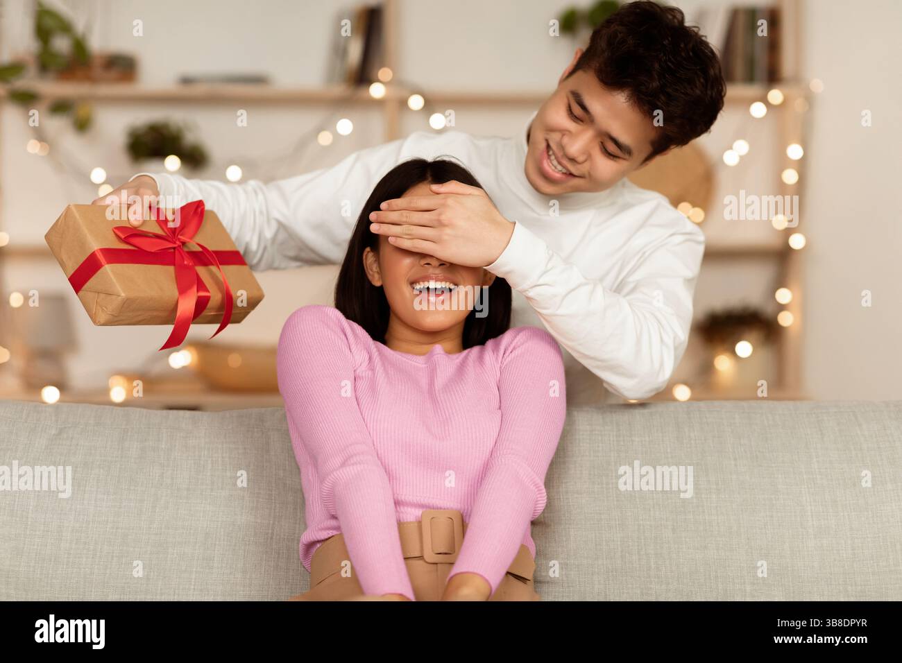 Husband Giving Christmas Gift To Wife, Covering Her Eyes Indoor Stock ...