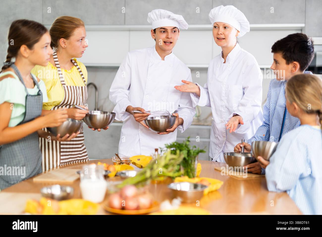 Two friendly chefs giving culinary lesson to group of tweens Stock ...