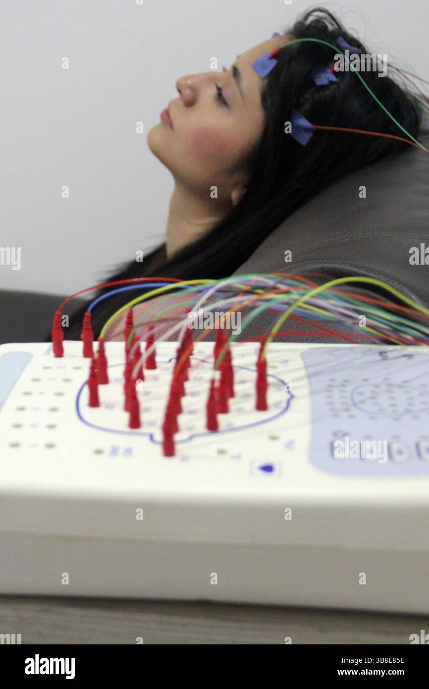 Electroencephalogram on a 20-year-old latin woman to measure brain electrical activity and ...