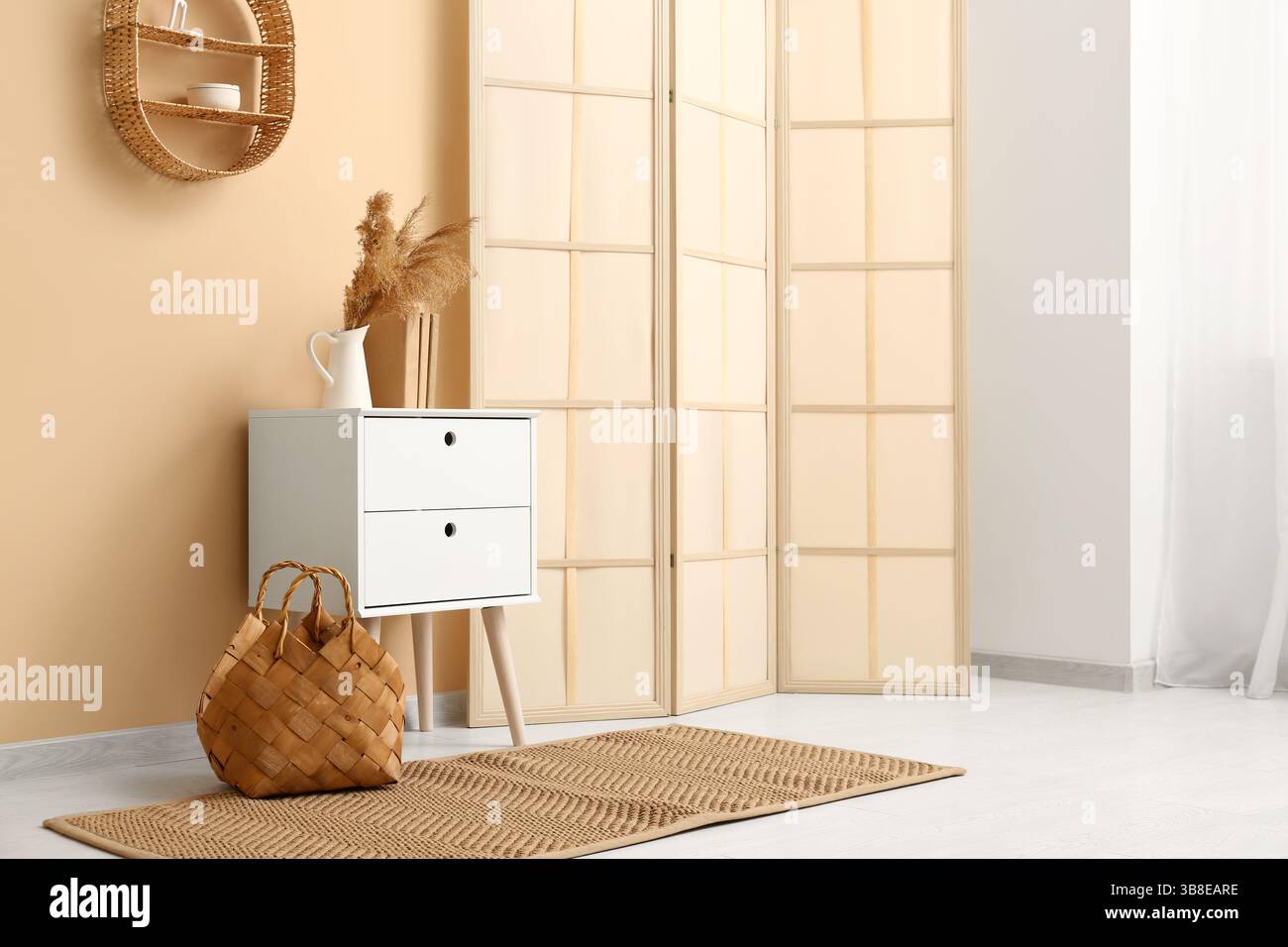 Interior of stylish room with pampas grass, table and folding screen ...