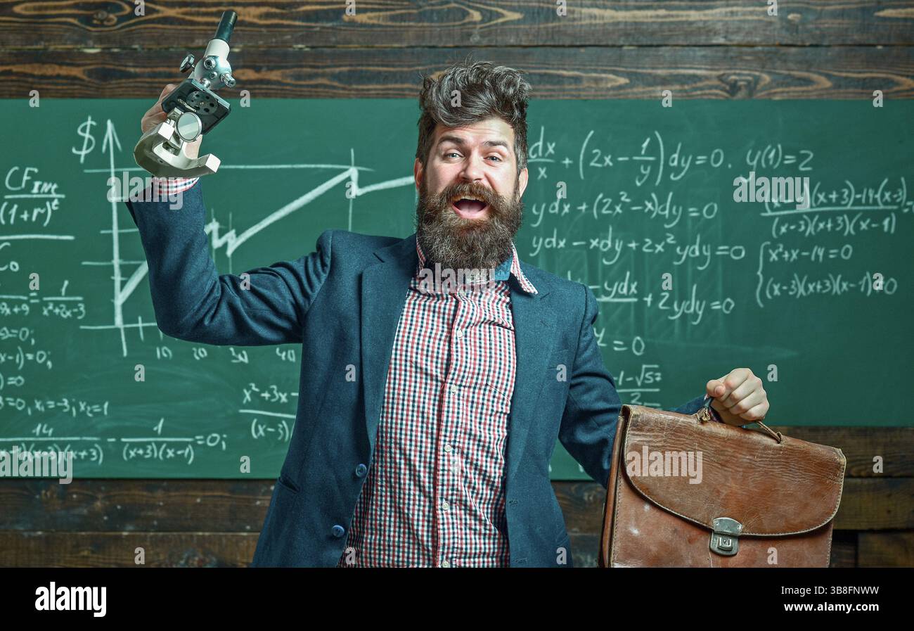 Teacher explains math at blackboard. Professor in classroom with ...