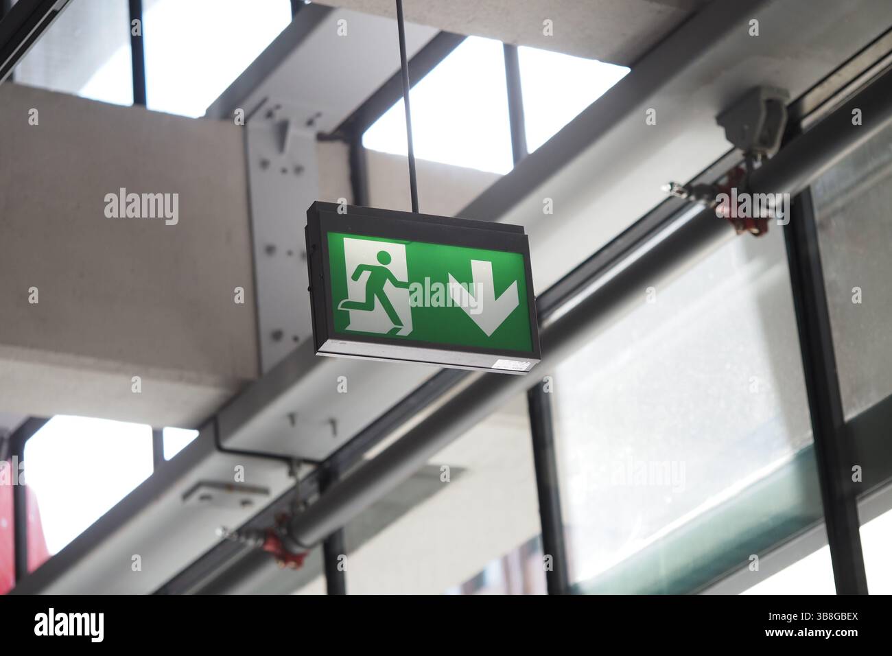 Emergency exit sign displayed inside a modern building Stock Photo - Alamy