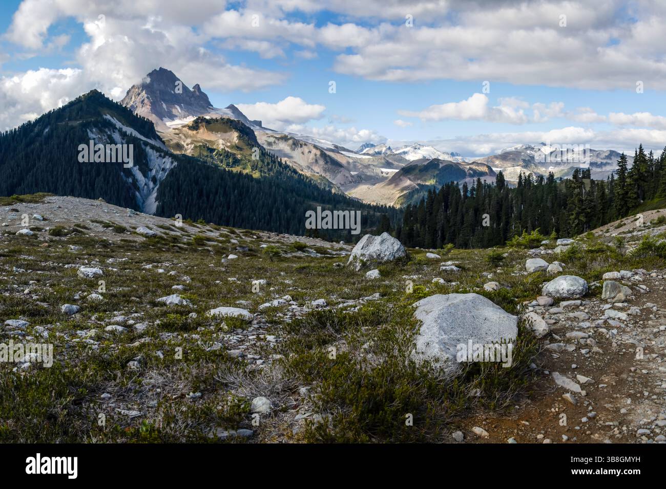 Breathtaking view featuring towering mountain peaks and rolling hills ...