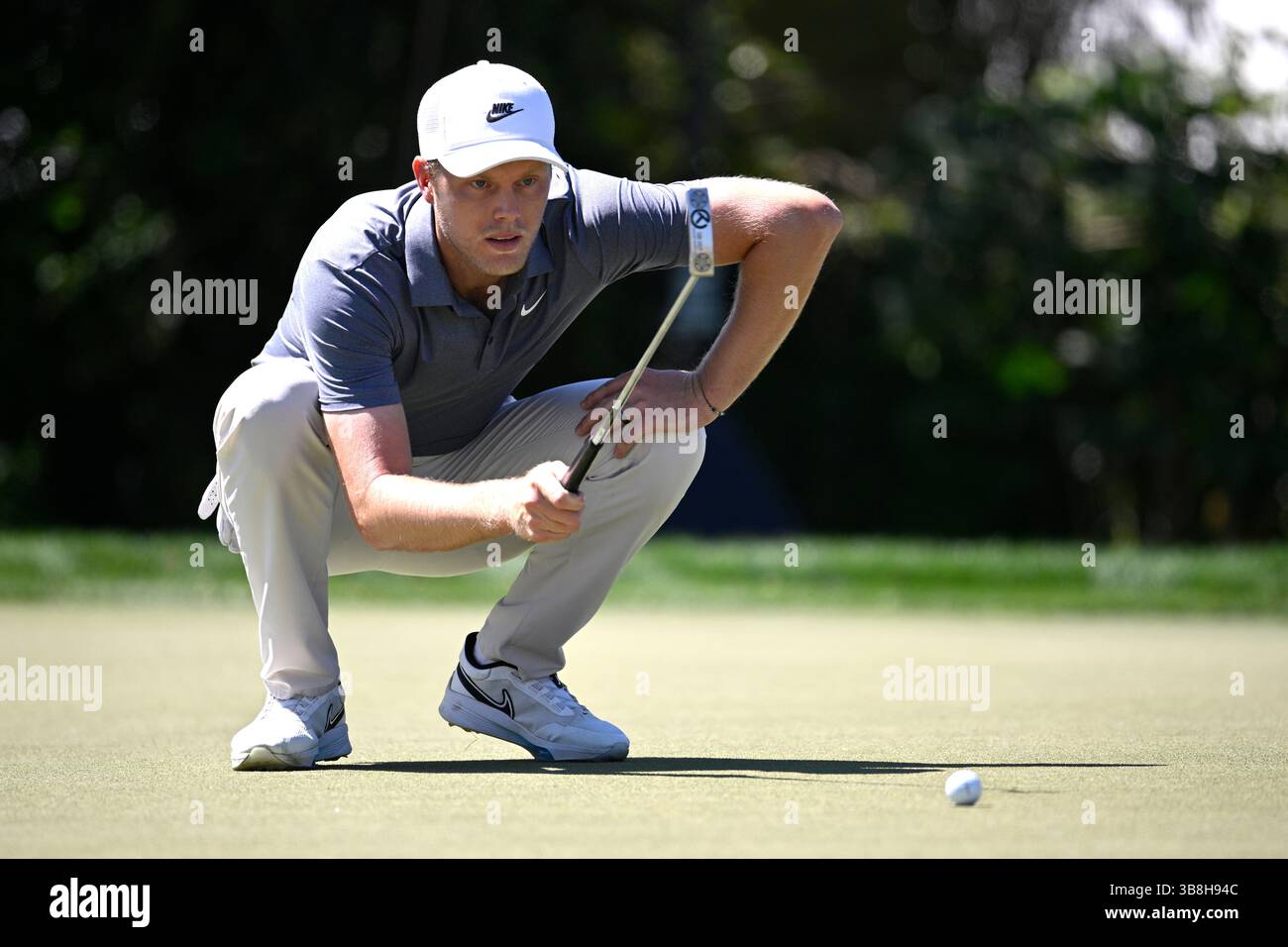 Cameron Davis, of Australia, lines up his putt on the first green ...