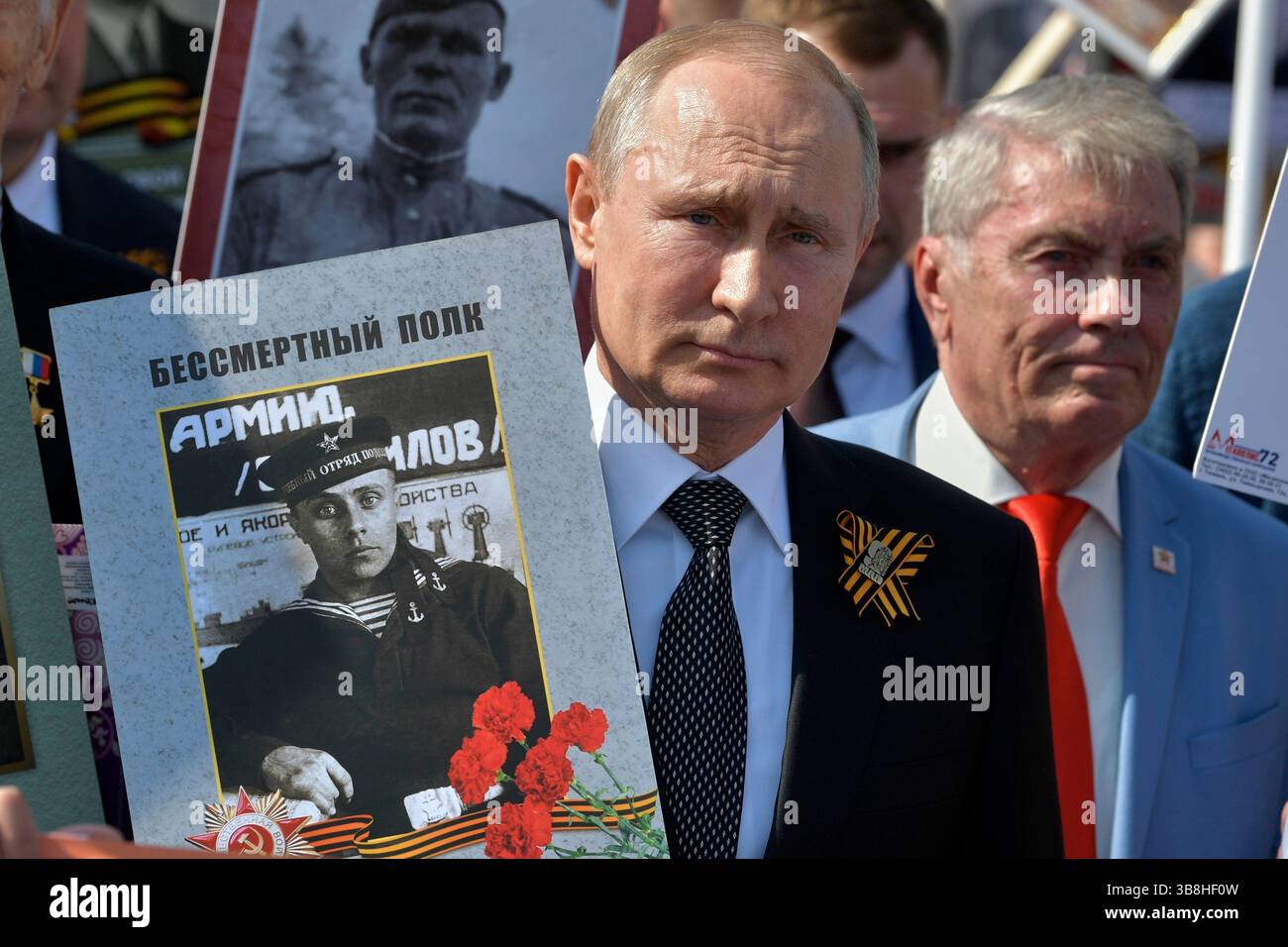 FILE - Russian President Vladimir Putin, center, holds a portrait of ...