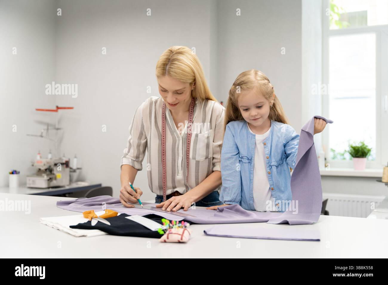 Blonde woman tailoring a new model in her design studio Stock Photo - Alamy