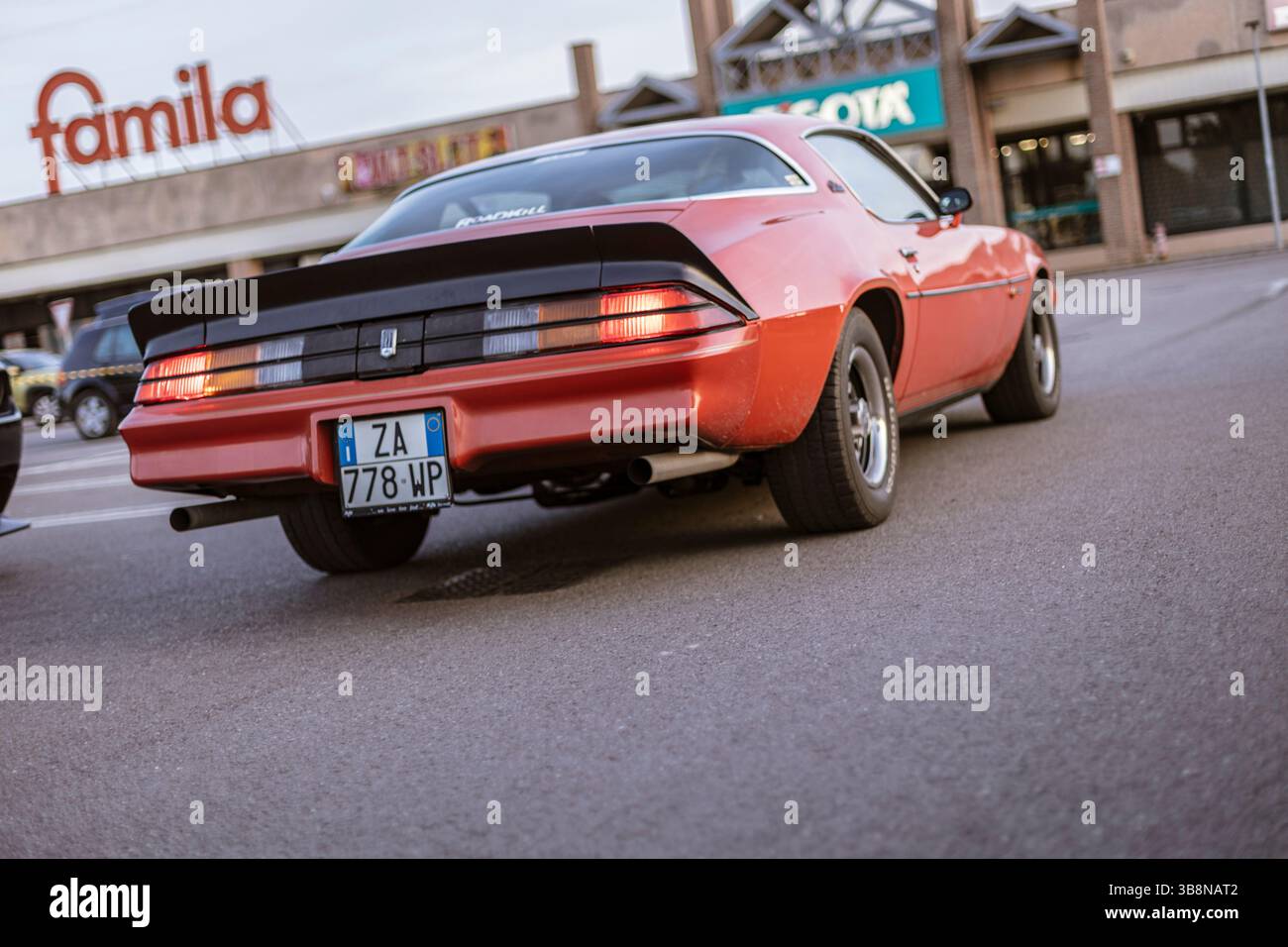 Rome, italy 4 may 2025: classic red chevrolet camaro driving away on ...