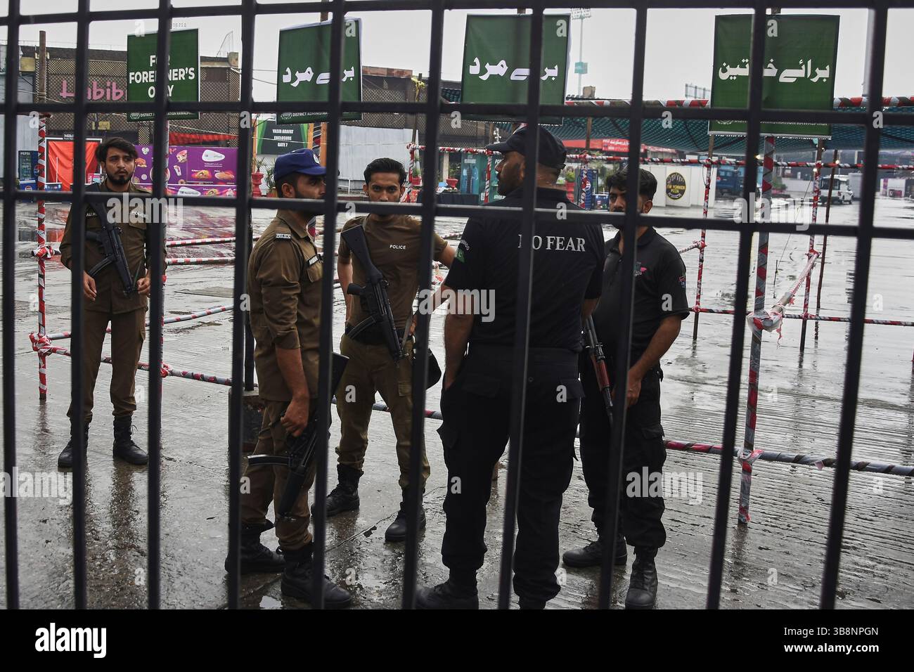 Police officers stand guard behind a closed gate of an entry point to ...