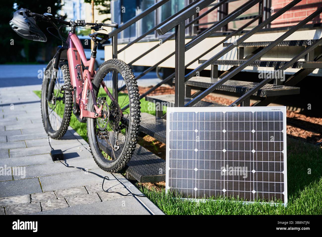 Pink electric mountain bike parked beside staircase, connected to small ...
