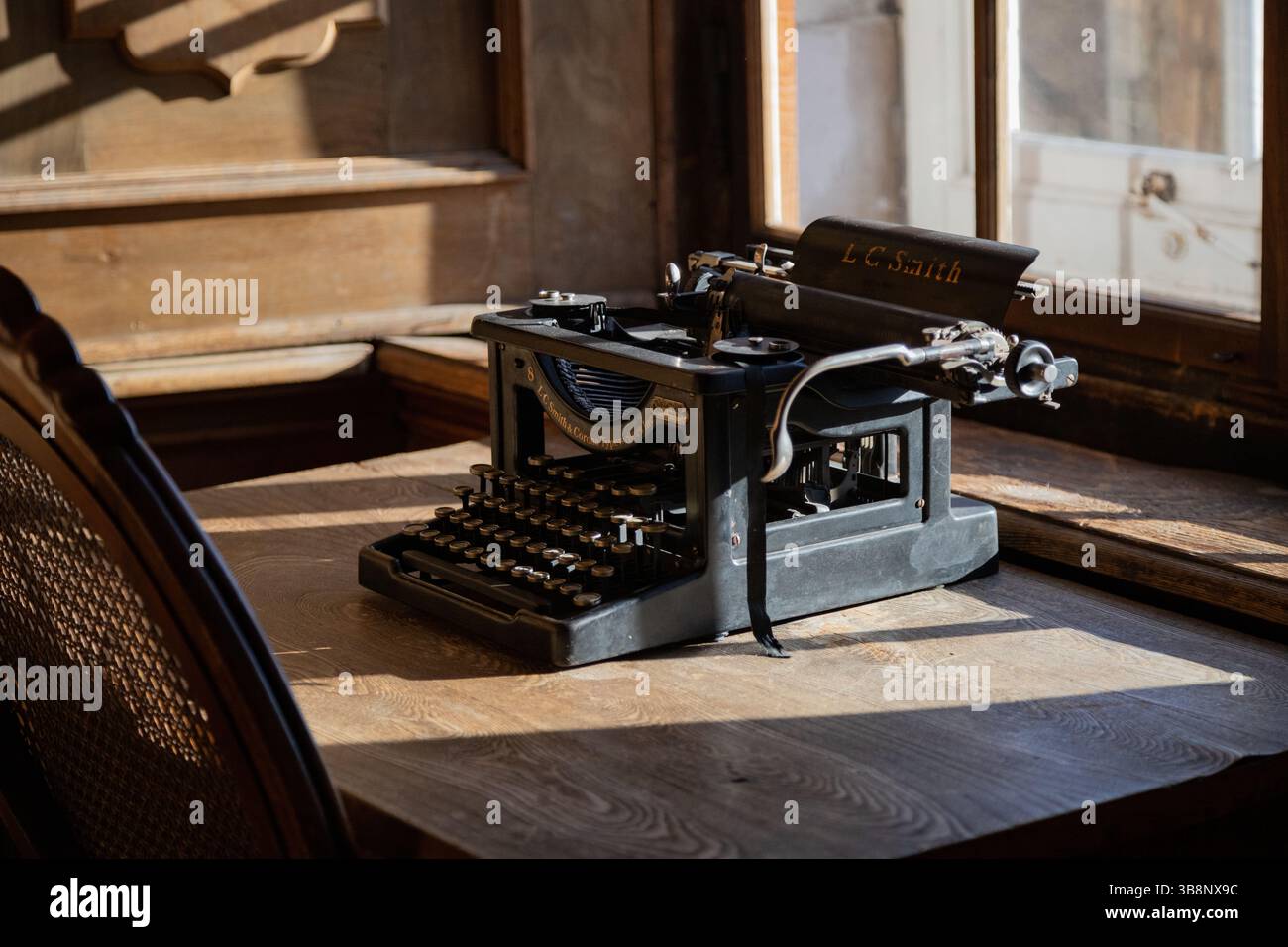 Black vintage typewriter on a desk at a window Stock Photo - Alamy
