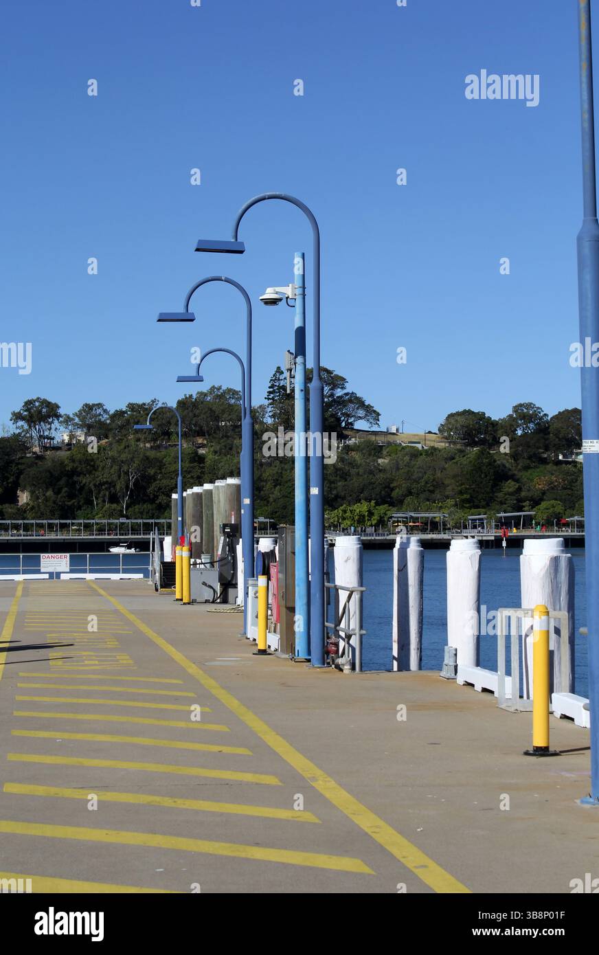Concrete dock pier with light poles and wooden posts at a marina Stock ...