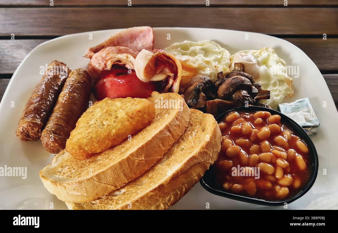 Full english breakfast on a plate, featuring fried eggs, bacon ...