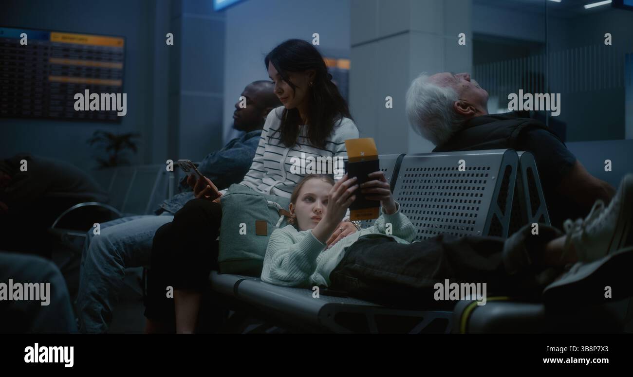 Mother and Daughter in Boarding Lounge of Airline Hub at Night: Tired Teen Girl Lying on Seats ...