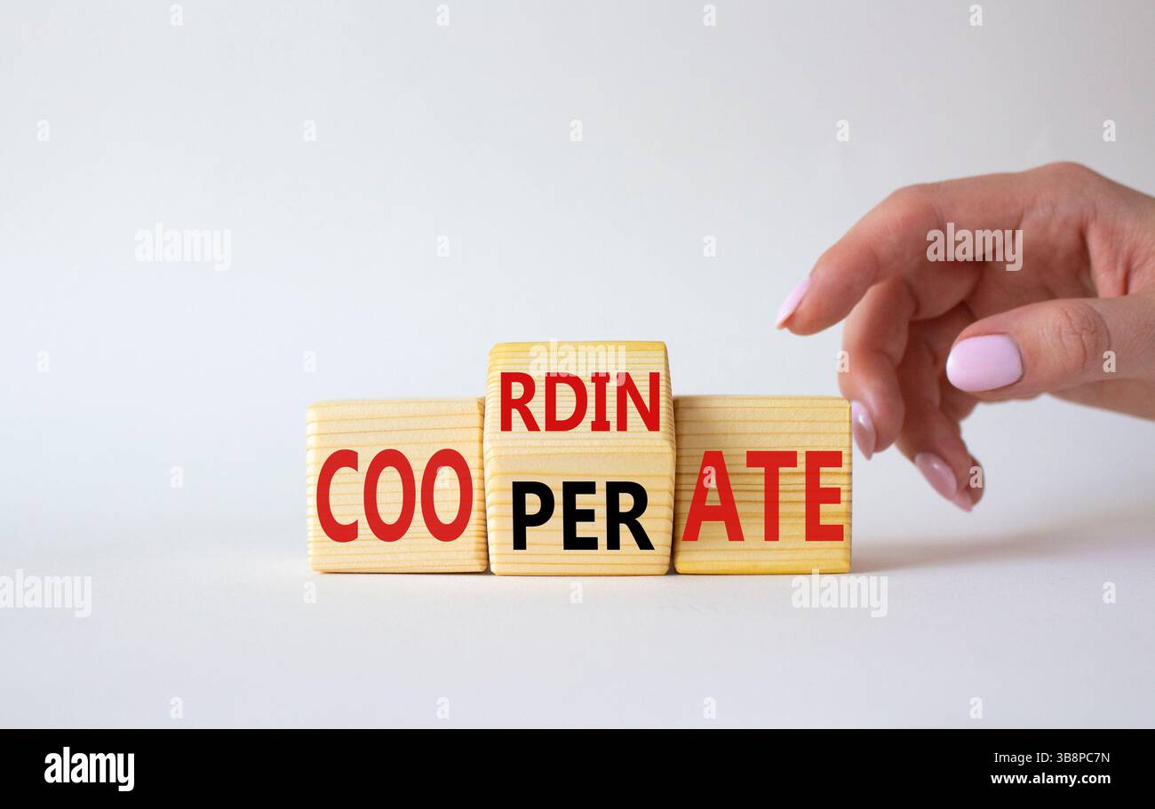 Cooperate and Coordinate symbol. Businessman hand points at wooden ...
