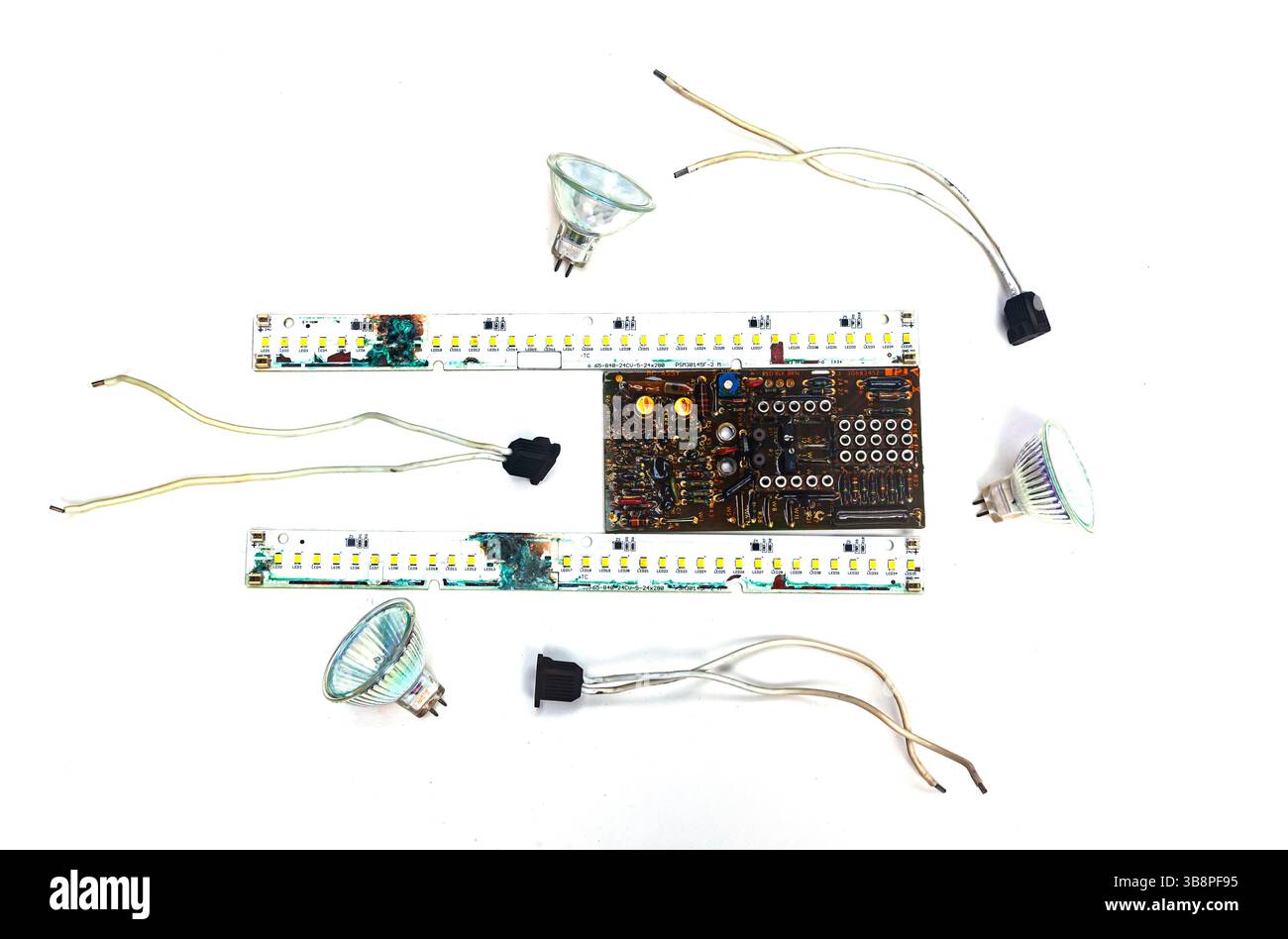 Burnt electric boards and microcircuits with light bulbs and wires on a ...