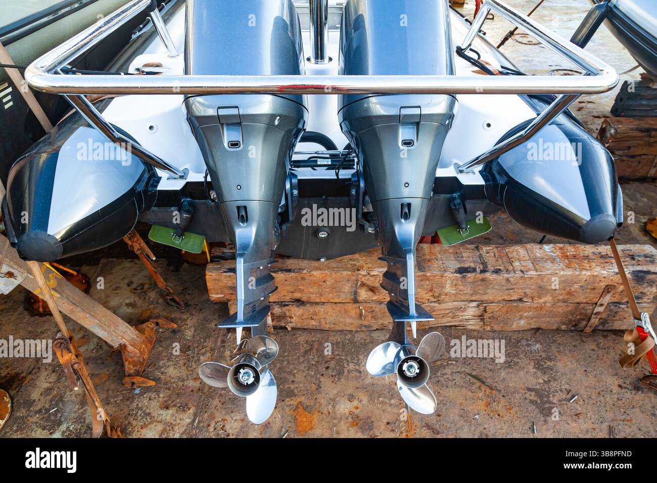 The back of a motor yacht dry docked on wooden blocks and supported by ...