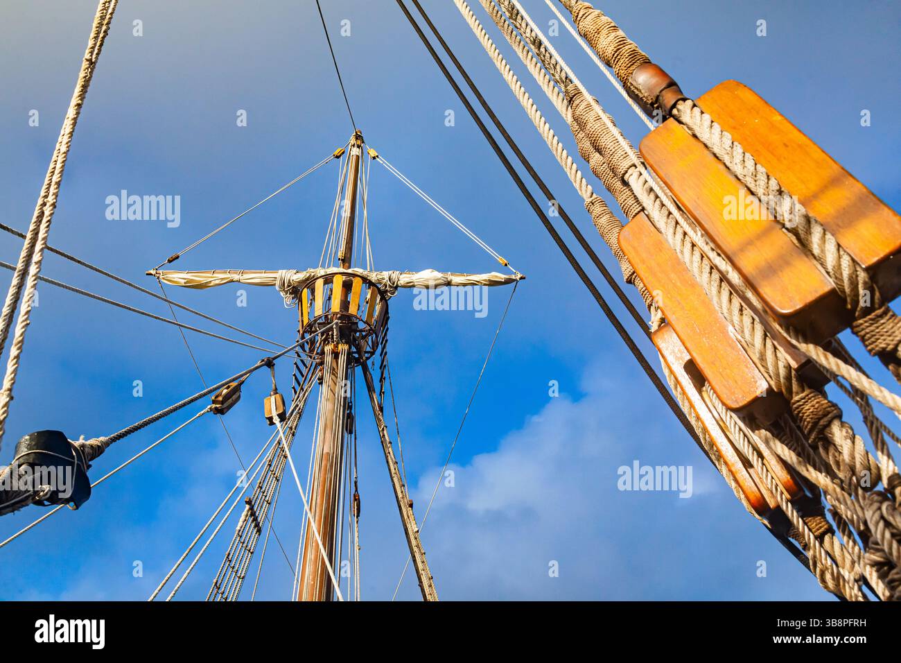 The mast of an old wooden ship with an observation basket on top, rope ...