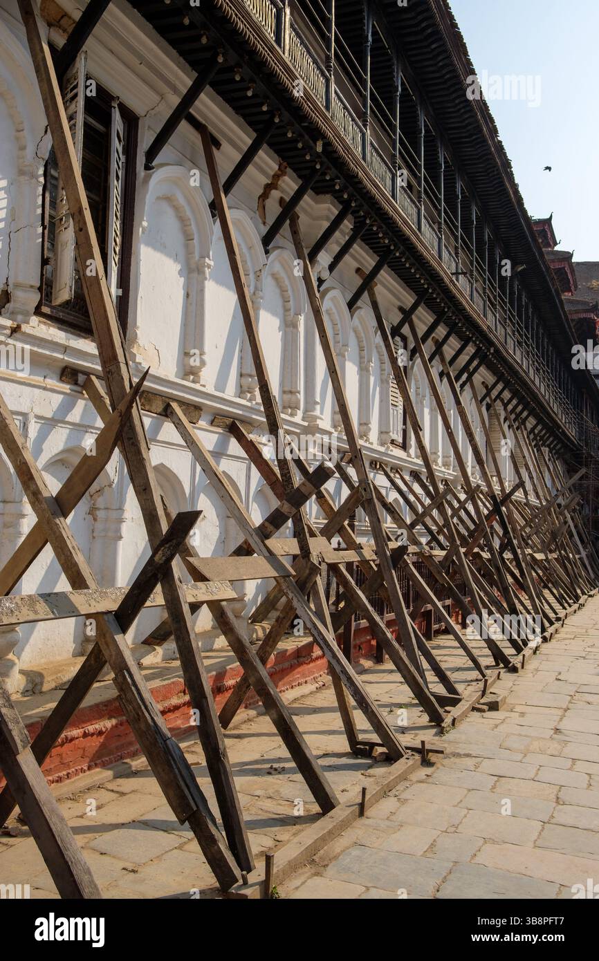 Wooden supports brace a damaged building in Nepal, likely after an ...