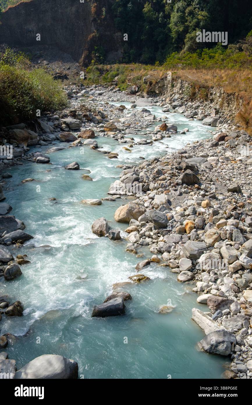 Glacial meltwater flows through a rocky riverbed, carving a path ...