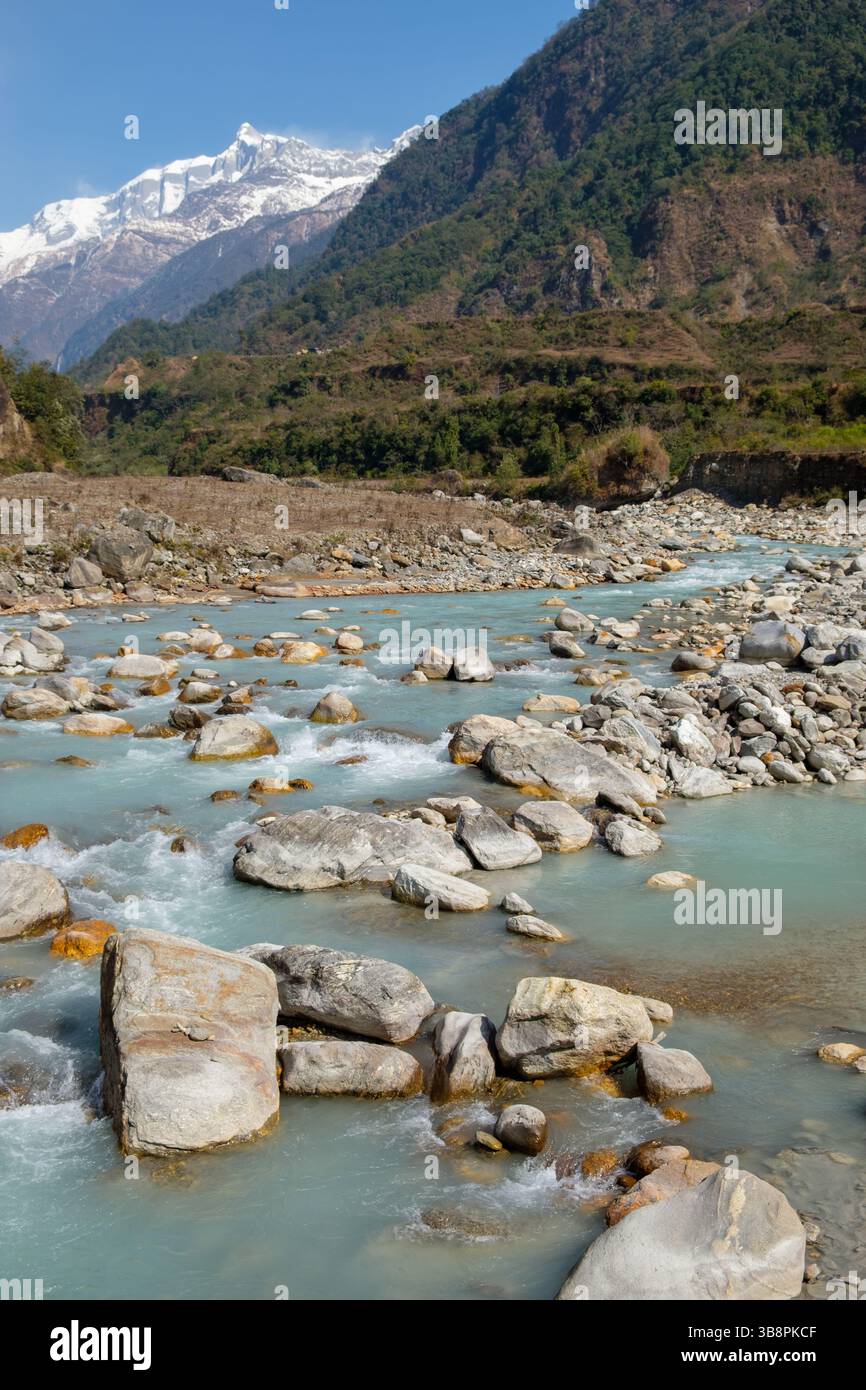 Glacial river flows through the mountains, carving a path through the ...