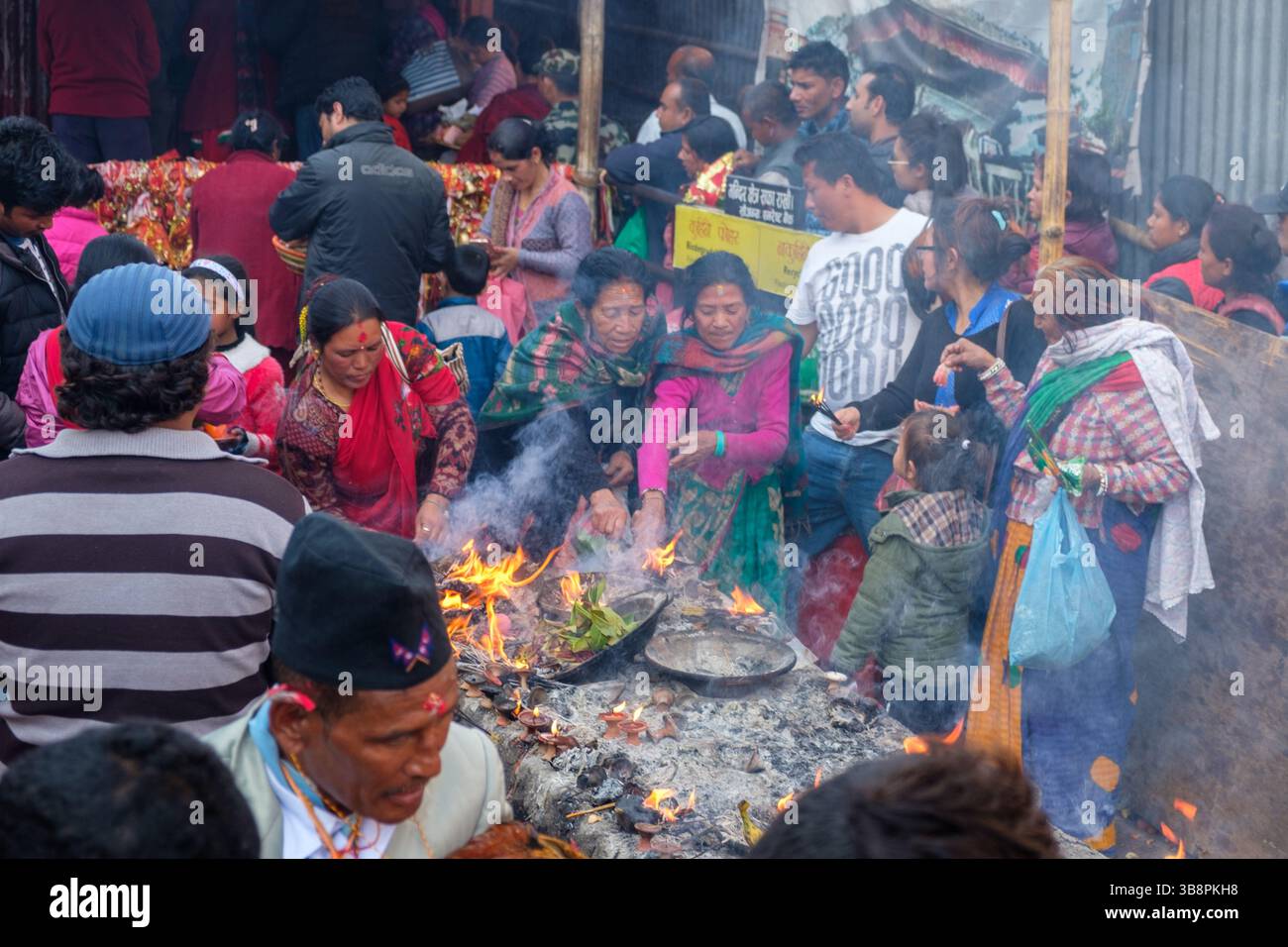 Devotees make offerings to a sacred fire during a Hindu ritual, seeking ...