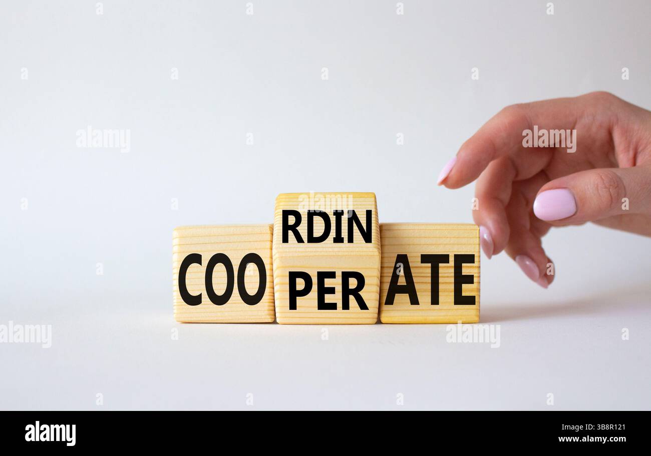 Cooperate and Coordinate symbol. Businessman hand points at wooden ...