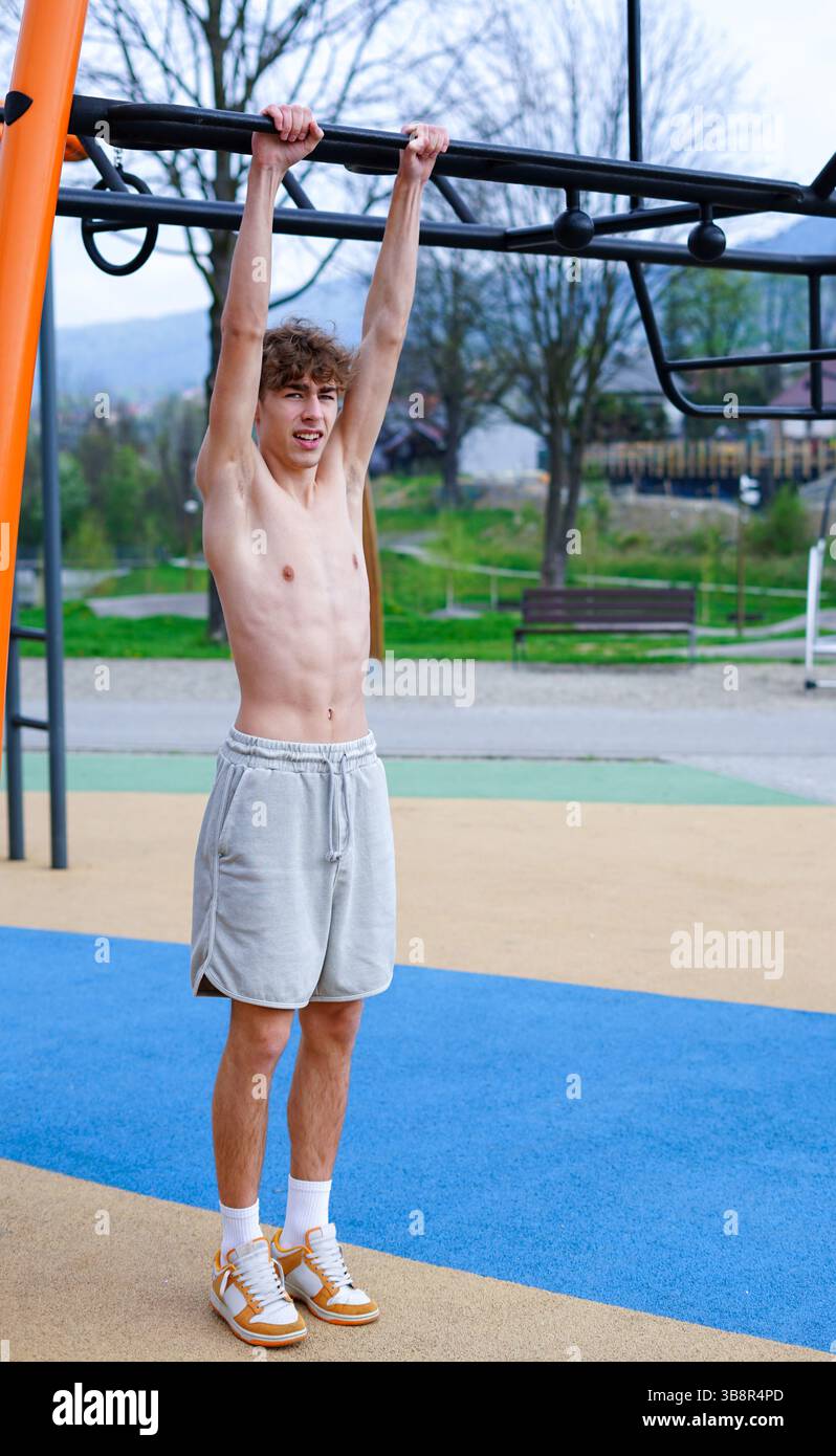 Fit guy doing strength training on a playground bar Stock Photo - Alamy