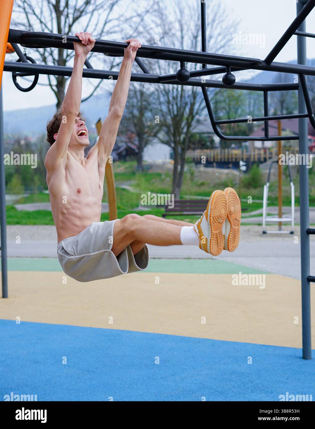 Athletic guy performing hanging leg raises on a playground Stock Photo ...