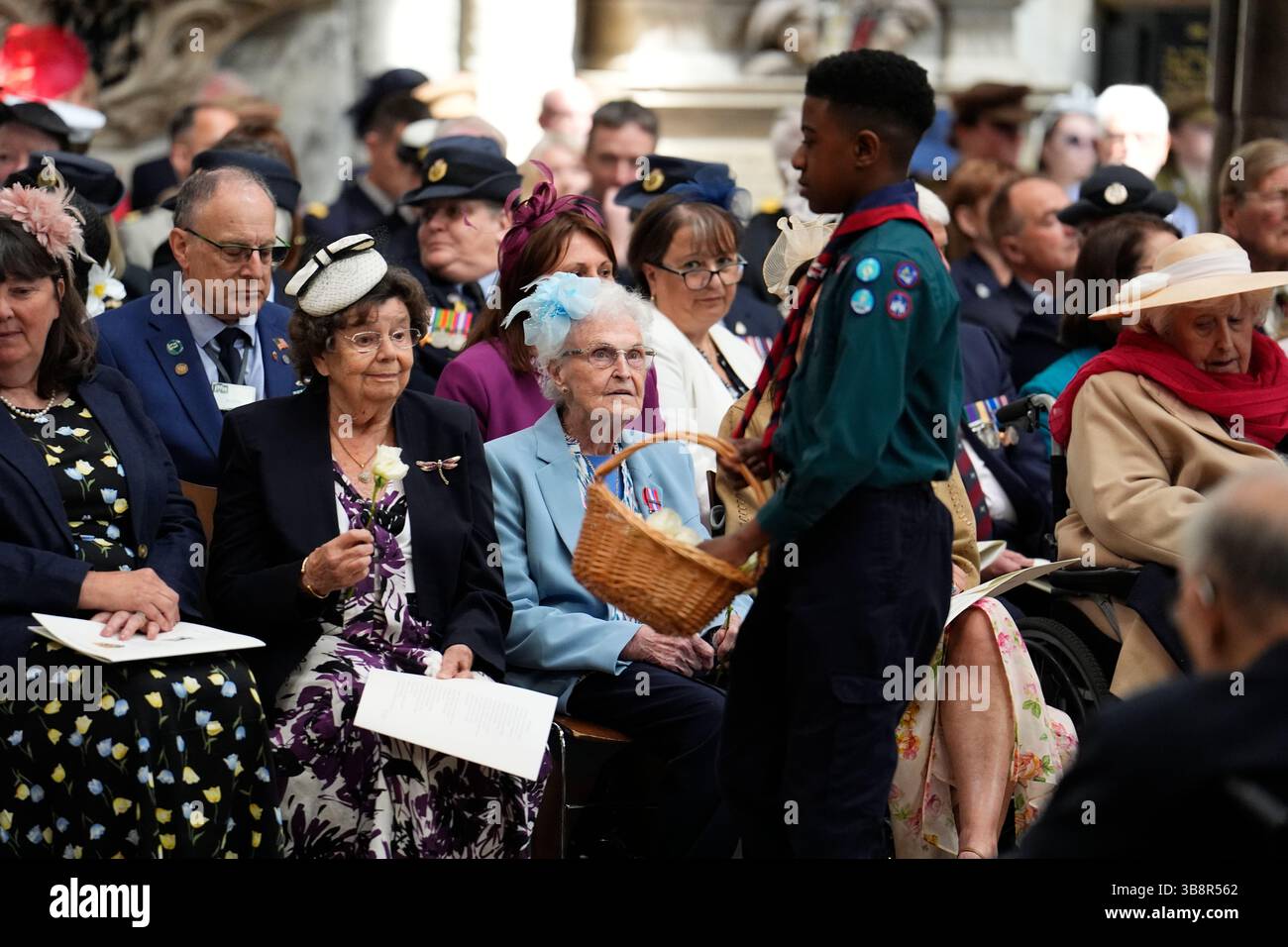 A Scout distributes white roses to Second World War veterans during a ...