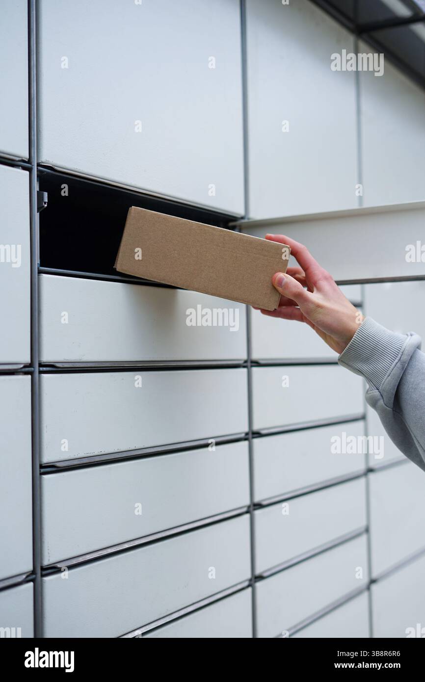 Close-up of a person inserting a package into an open locker of an ...