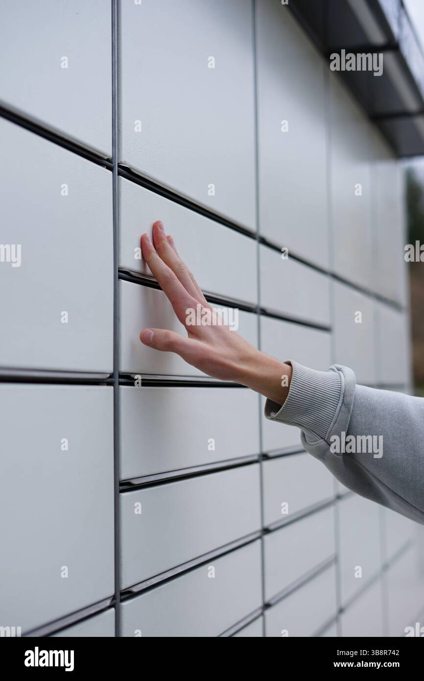 Close-up of a hand pushing locker door shut after parcel retrieval ...