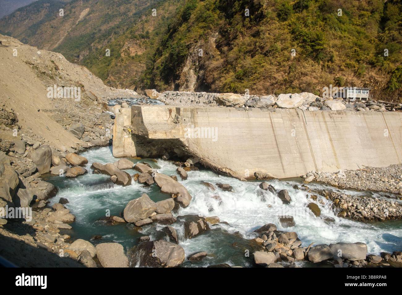 A damaged dam in a mountainous region, likely for hydroelectric power ...