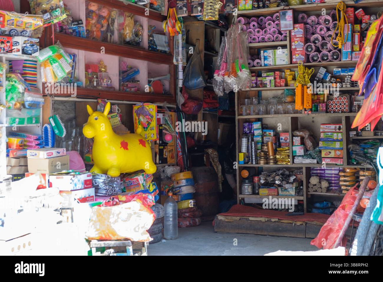 A small shop is packed with goods, from toys to hardware, catering to ...