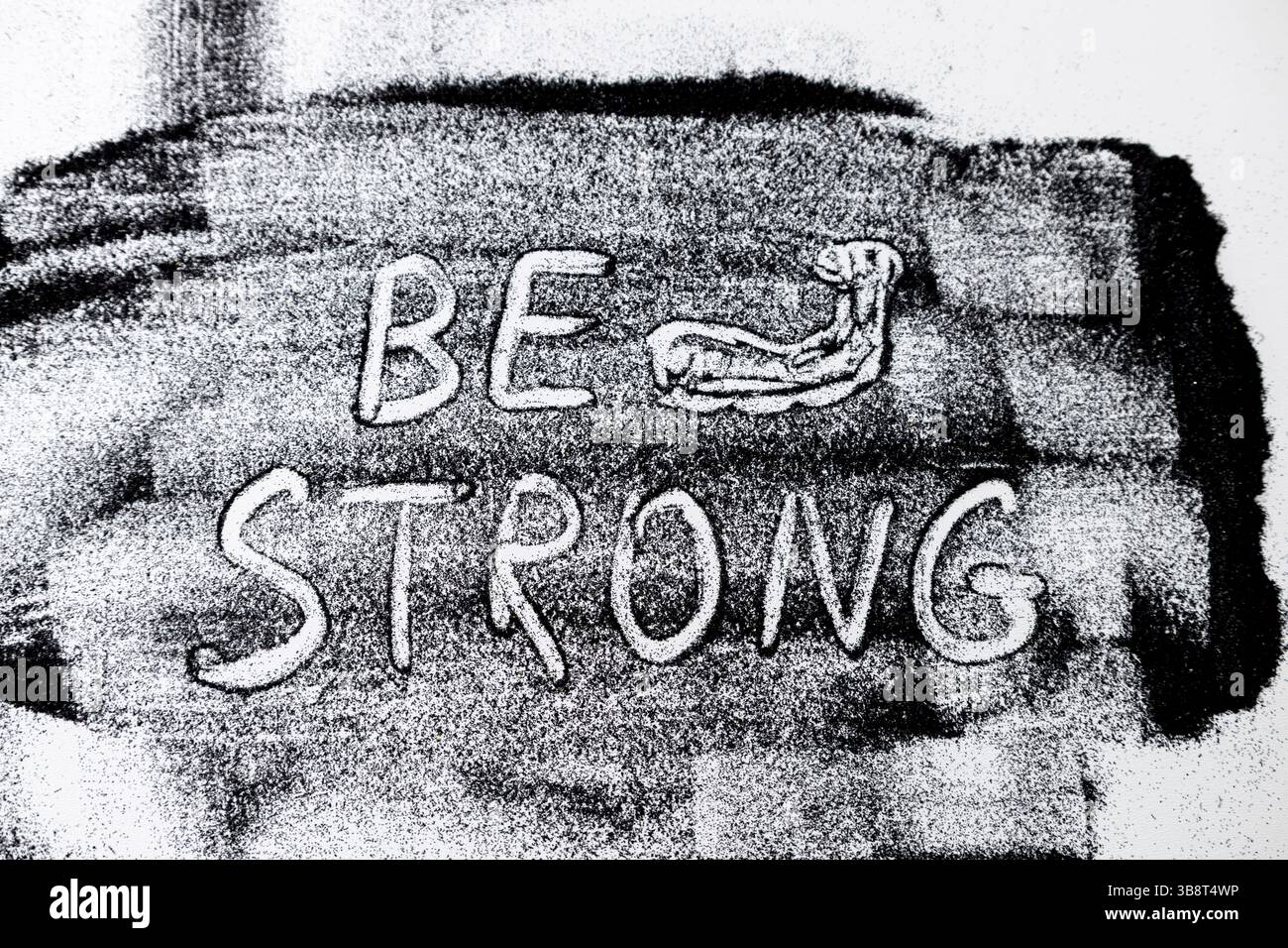 On the black glitters drawing words BE STRONG and the arm with muscle ...