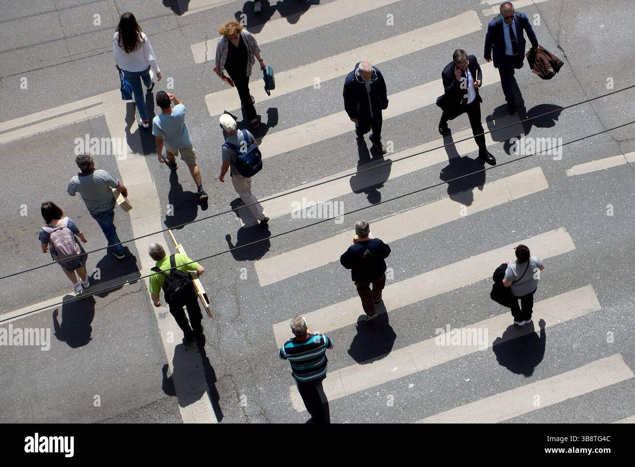 Bucharest, Romania. 7th May, 2025: People pass through a busy crosswalk ...
