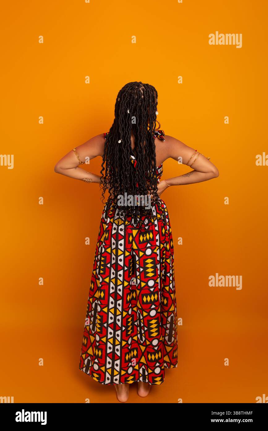 Beautiful young woman with braids in her hair, standing with her back ...