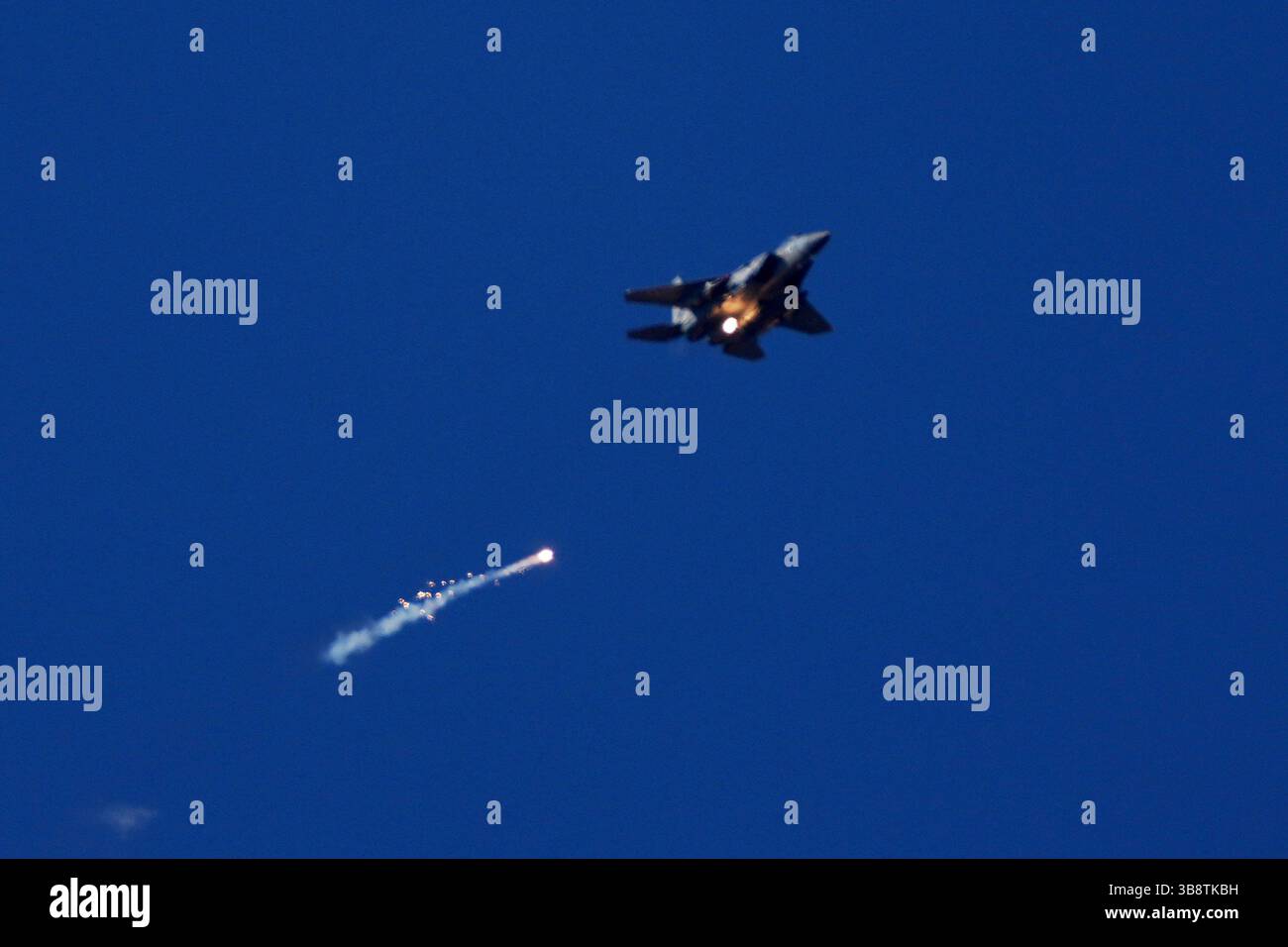 An Israeli Air Force fighter jet releases flares over the Gaza Strip ...