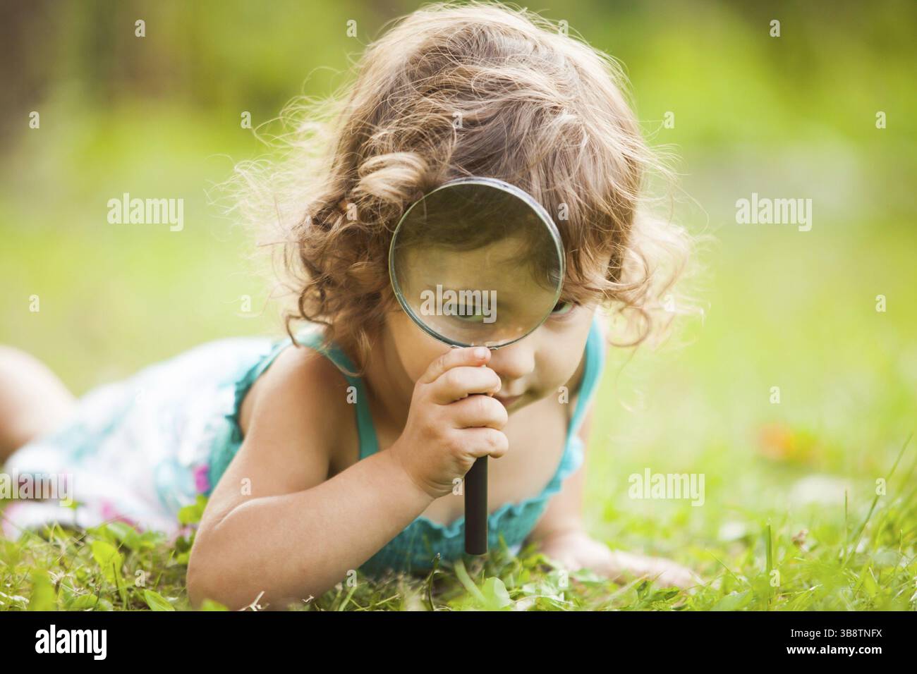 Kid plays with magnifying glass in the garden Stock Photo - Alamy