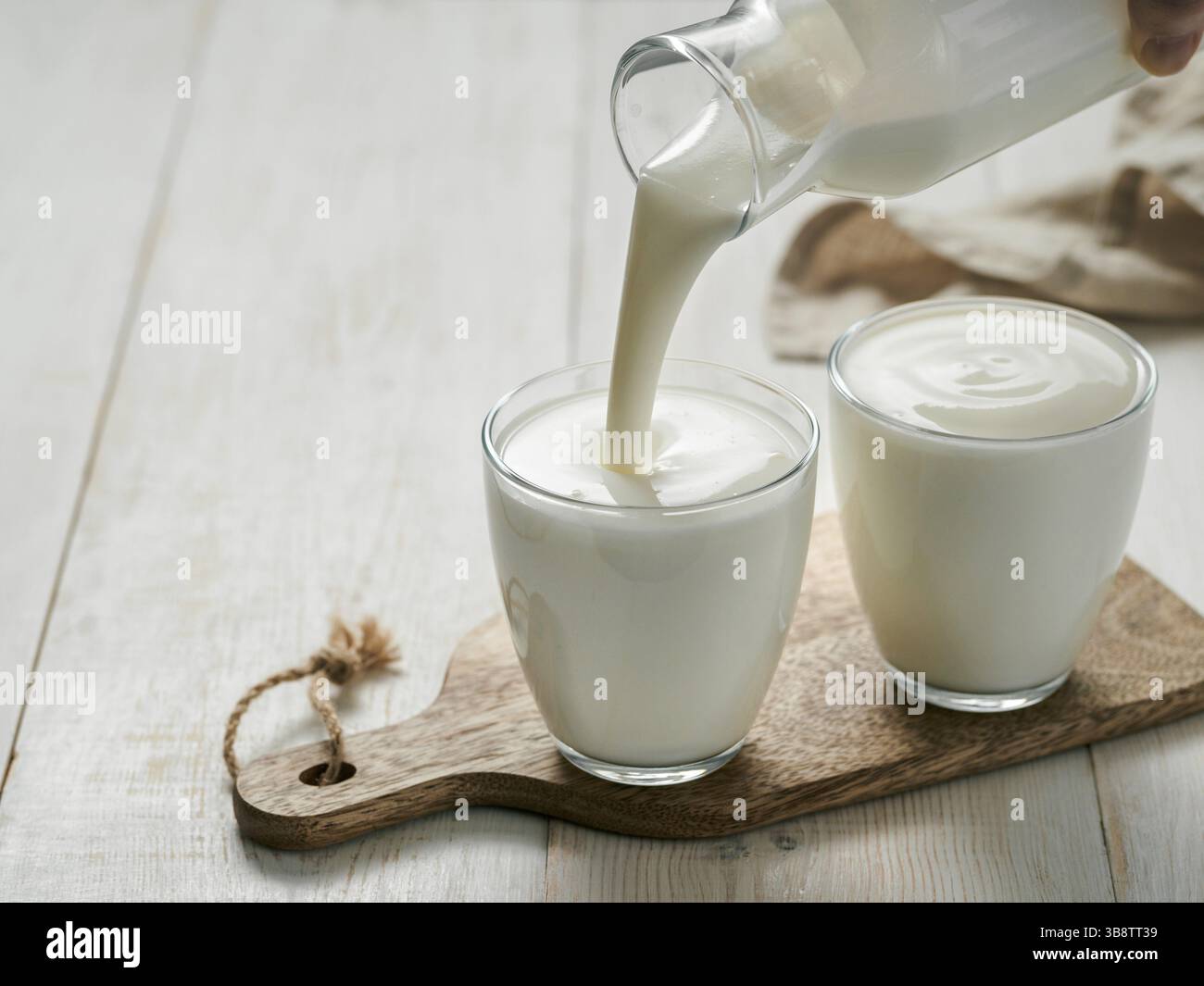 Pouring homemade kefir, buttermilk or yogurt with probiotics. Yogurt ...