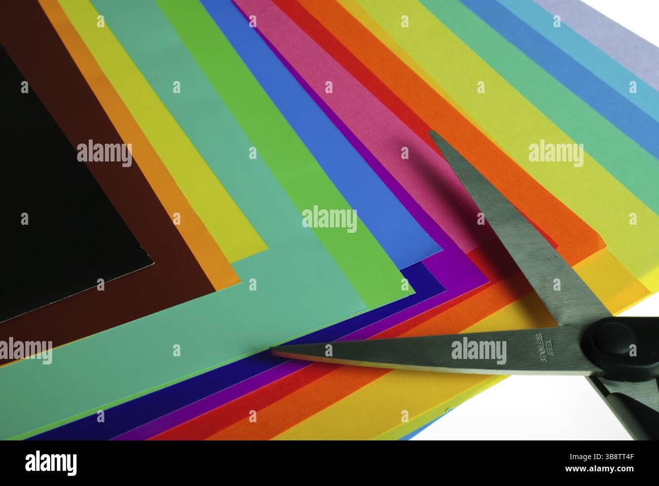 Various color paper stack like a rainbow and pair of scissors isolated ...