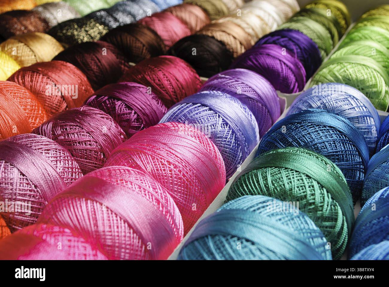 Different color threads on rows in the store Stock Photo - Alamy