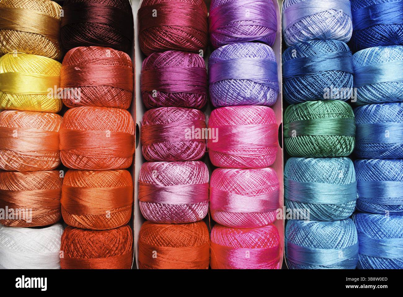 Different color threads on rows in the store Stock Photo - Alamy