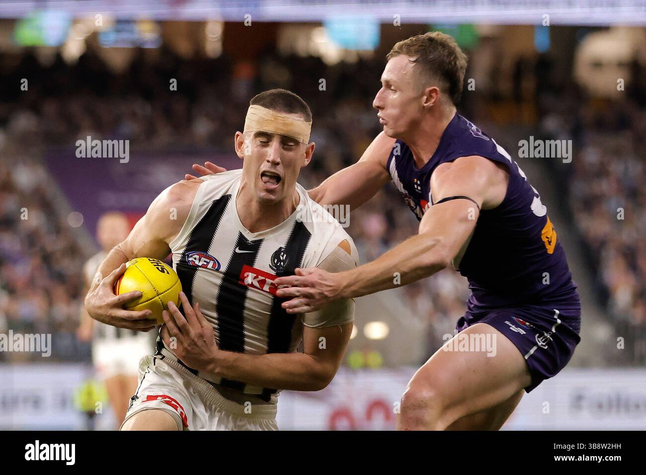 Darcy Cameron of the Magpies is tackled by Josh Treacy of the Dockers ...