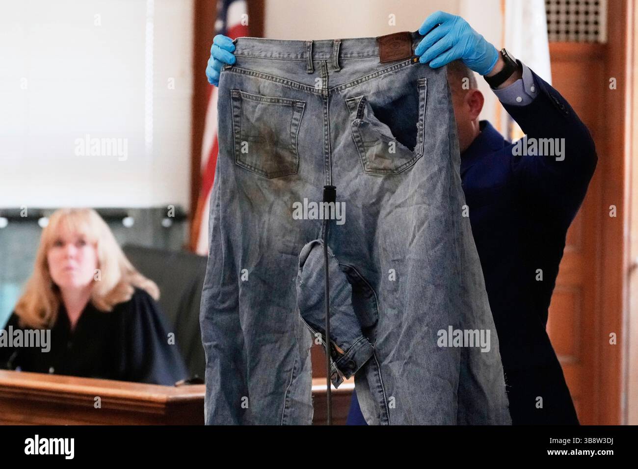 Massachusetts State Police Sergeant Yuriy Bukhenik holds up the pants which John O'Keefe wore ...