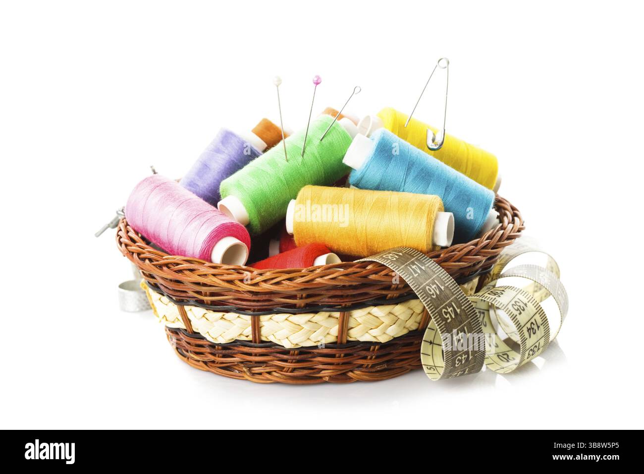 Sewing items in basket: threads, pins, meter and scissors on white ...