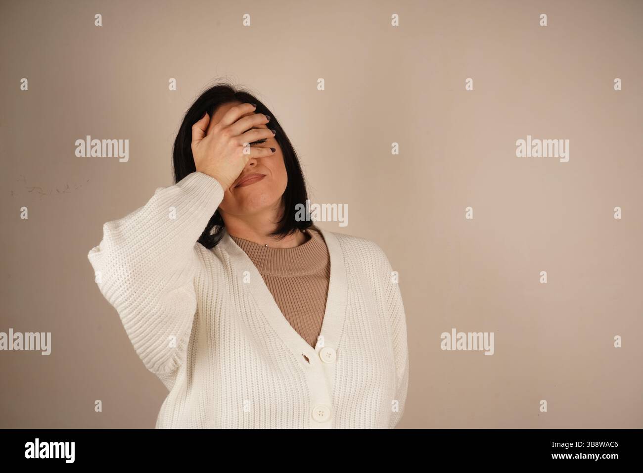 The woman touches her temple with one hand, signaling the agony of a ...