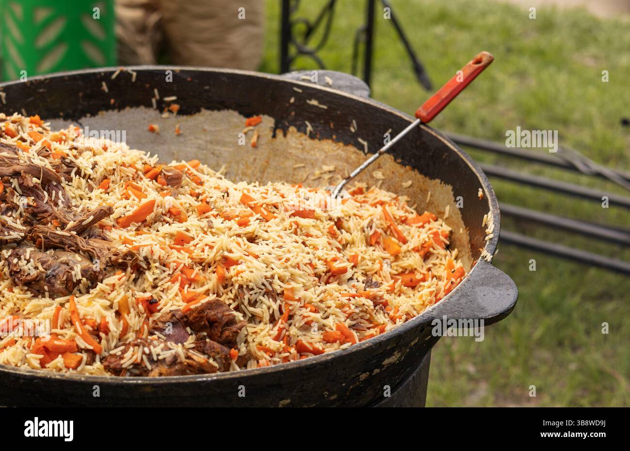 Street food festival pilaf in a cauldron close-up. Traditional oriental ...