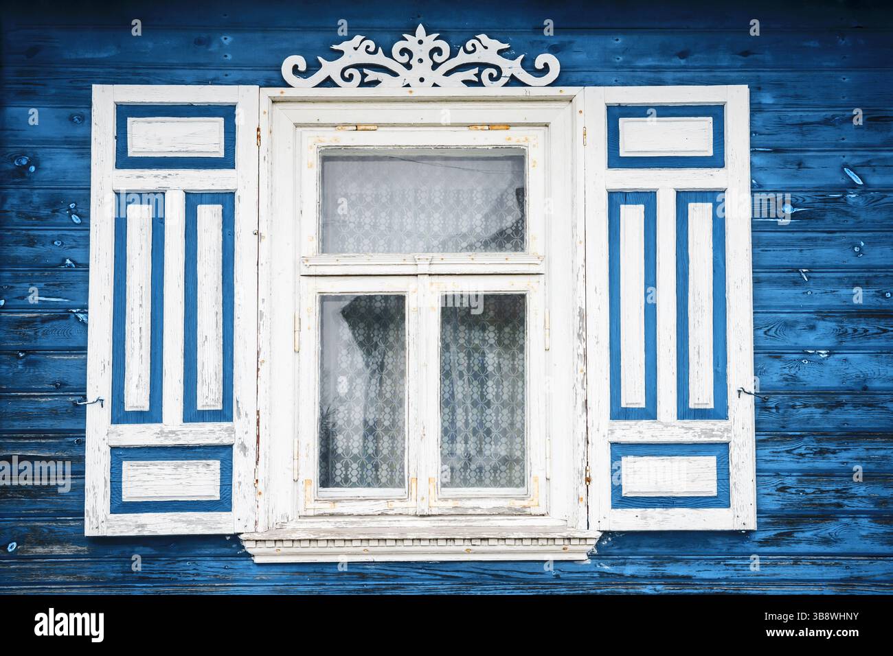 Old blue house window with white decorative frame. Traditional ...